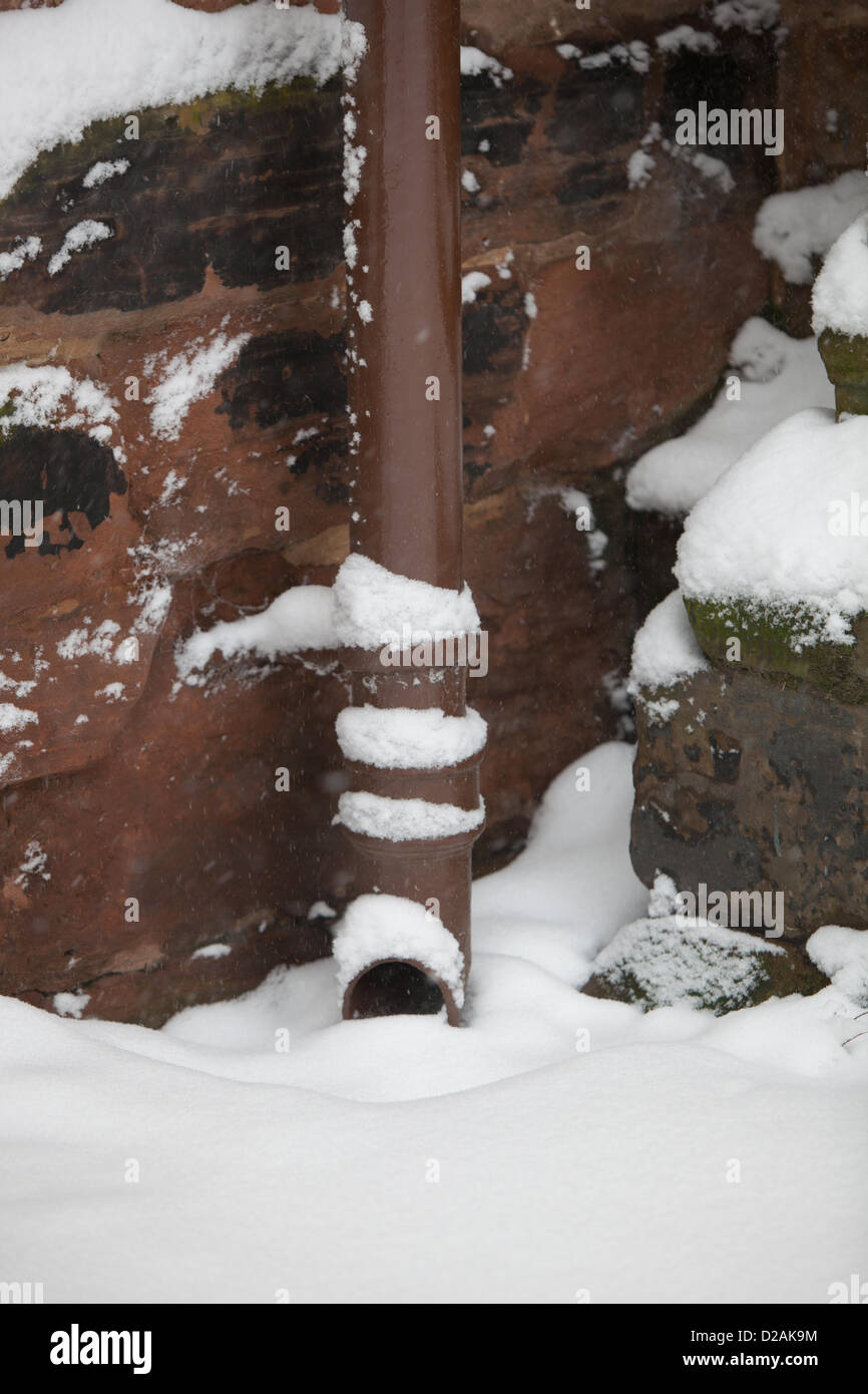 Drainpipe and drain covered in snow Stock Photo - Alamy