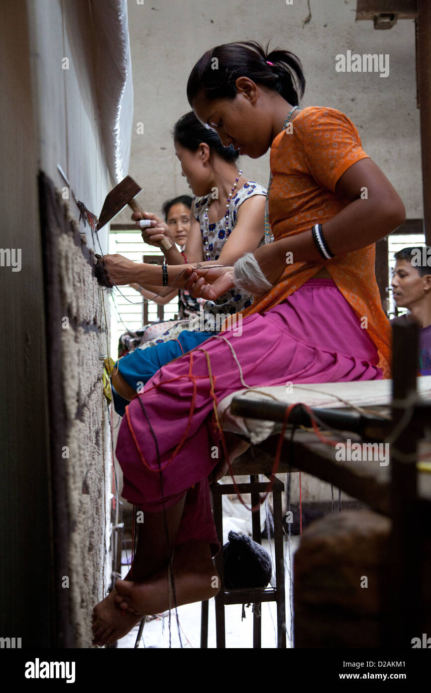 Female weavers at Amity Carpet Factory sit by their loom working on ...