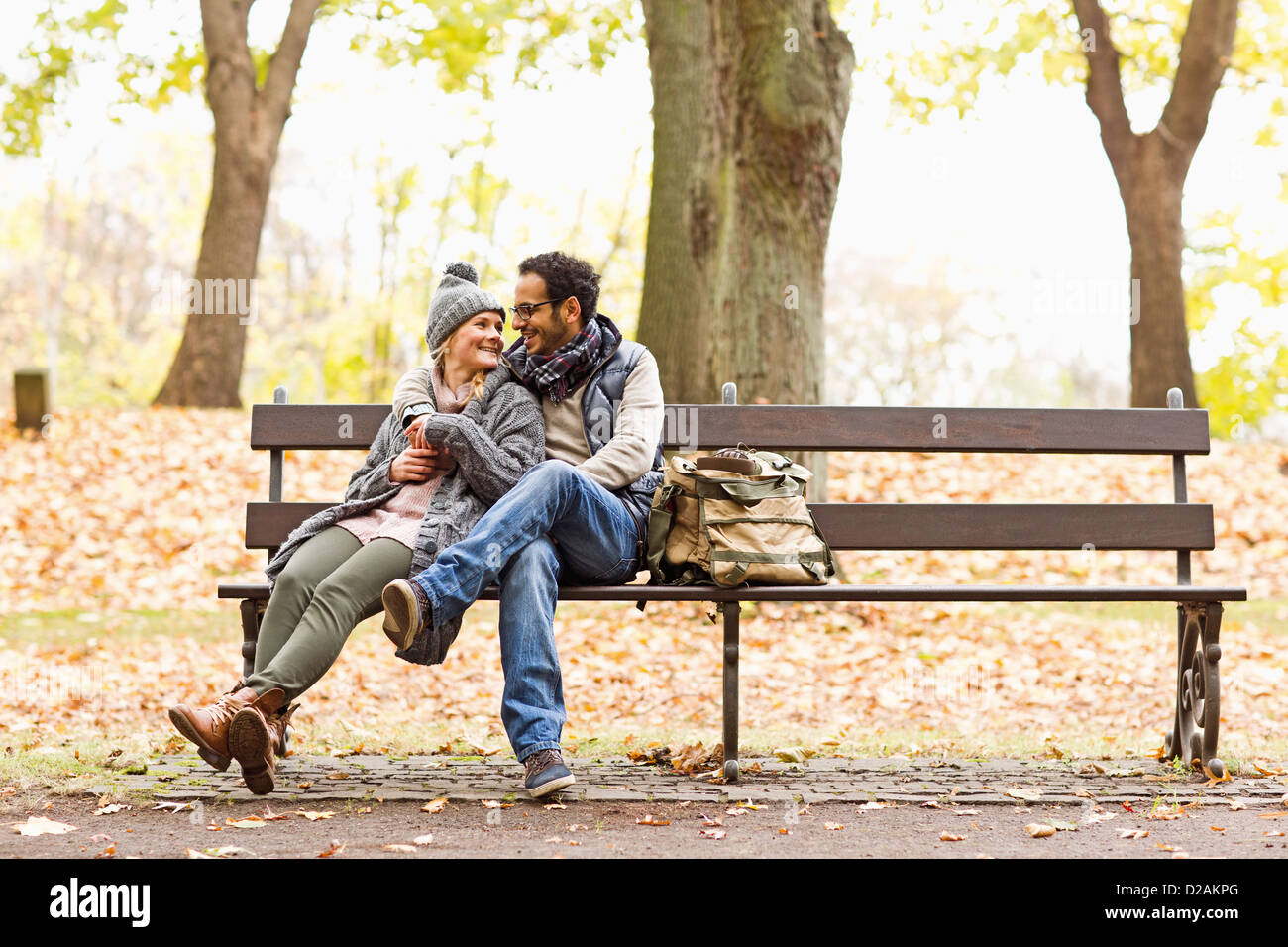 Smiling couple sitting on park bench Stock Photo - Alamy