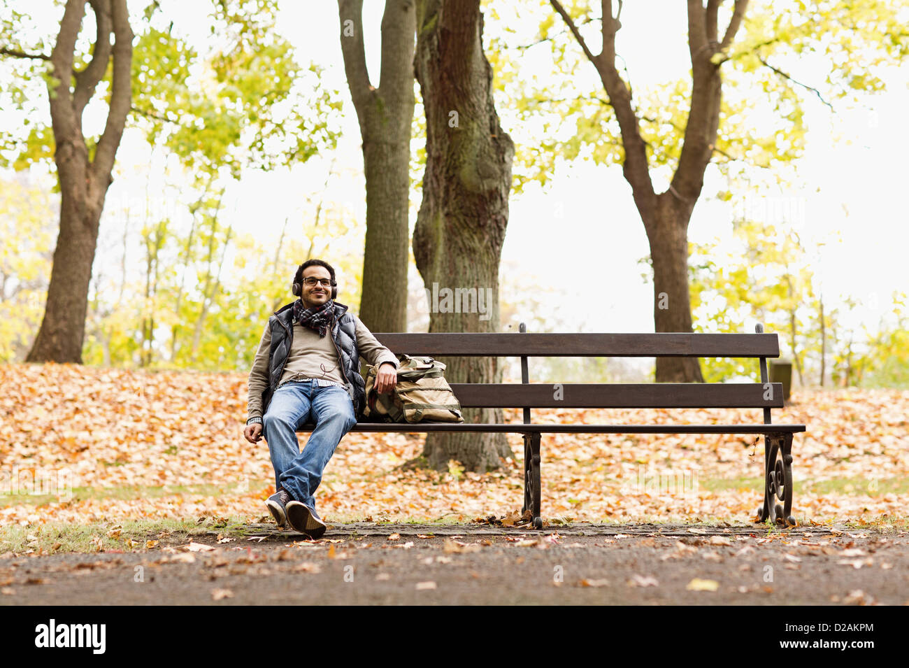 Smiling man sitting on park bench Stock Photo - Alamy