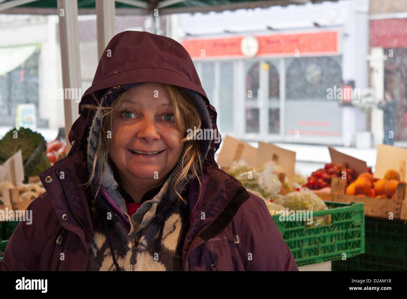 Happy market trader at her fruit and vegetable stall in the town centre ...
