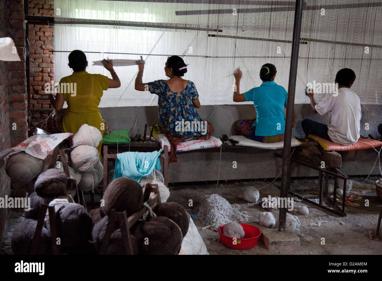 Workers busy weaving a big carpet on a traditional loom at Ashal Carpet ...