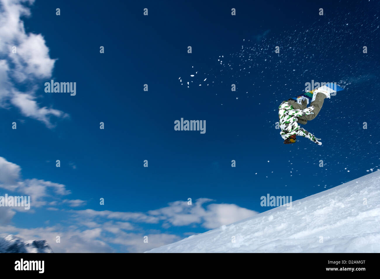 Snowboarder jumping on snowy slope Stock Photo - Alamy