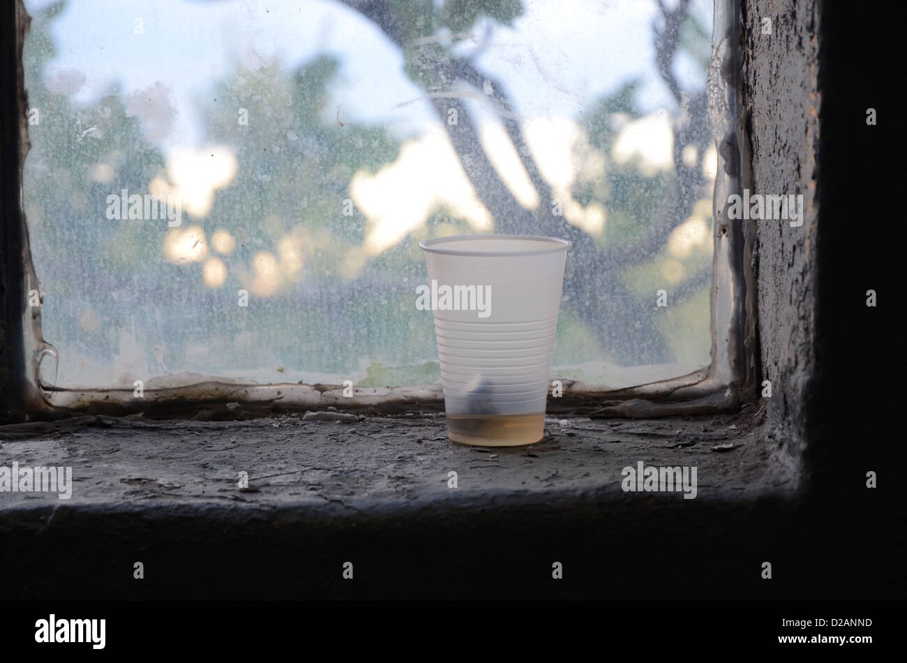 Plastic glass in front of dirty window Stock Photo - Alamy