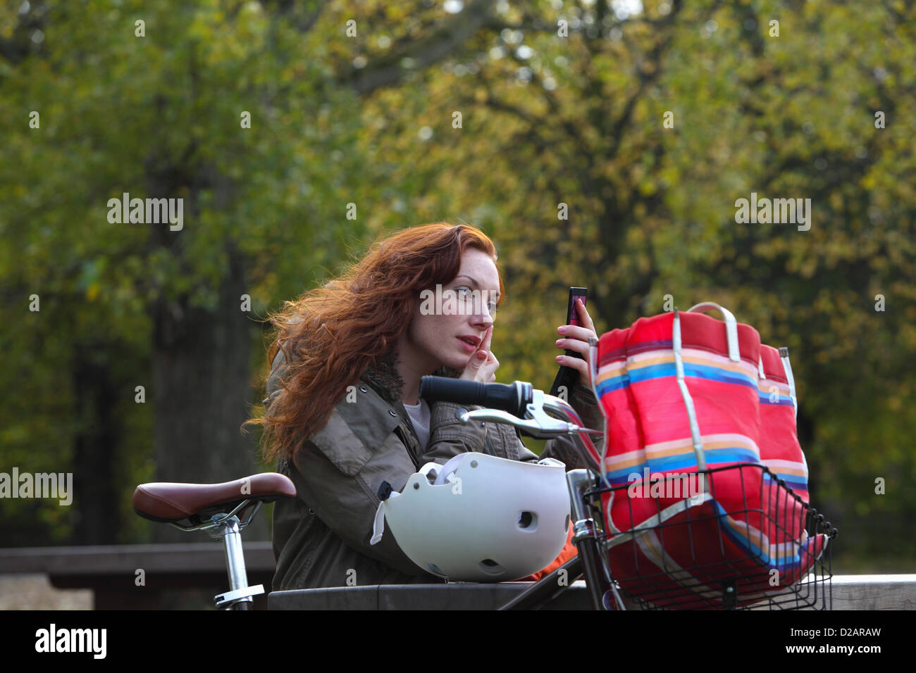 Woman applying makeup in park Stock Photo - Alamy