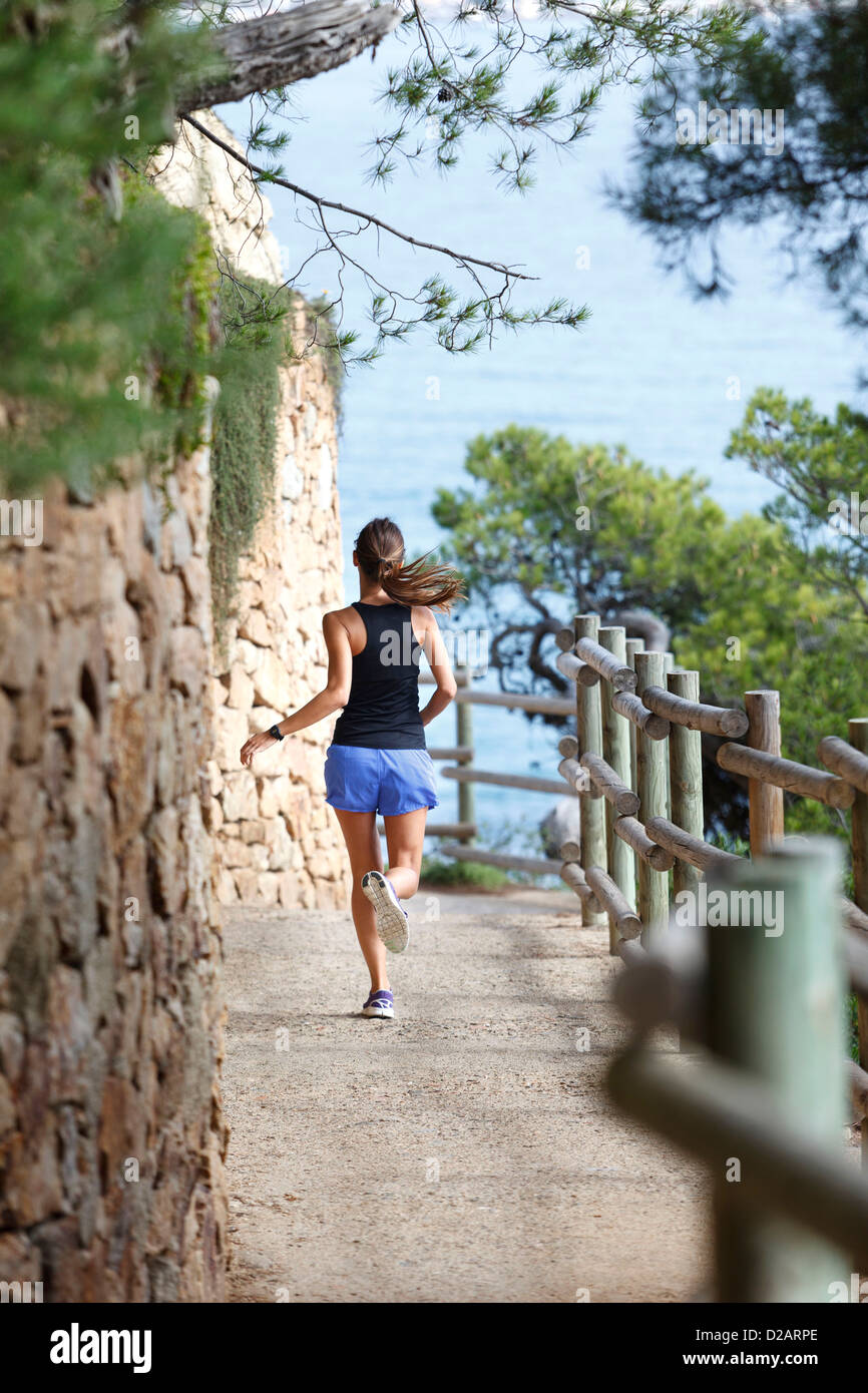 Woman running on dirt path Stock Photo - Alamy
