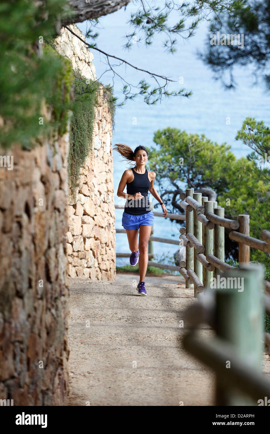 Woman running on dirt path Stock Photo - Alamy