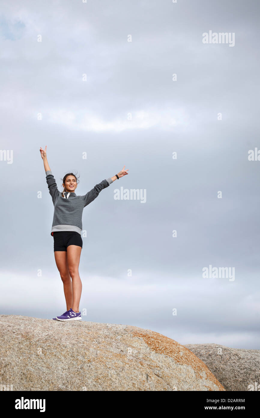 Woman cheering on boulder Stock Photo - Alamy