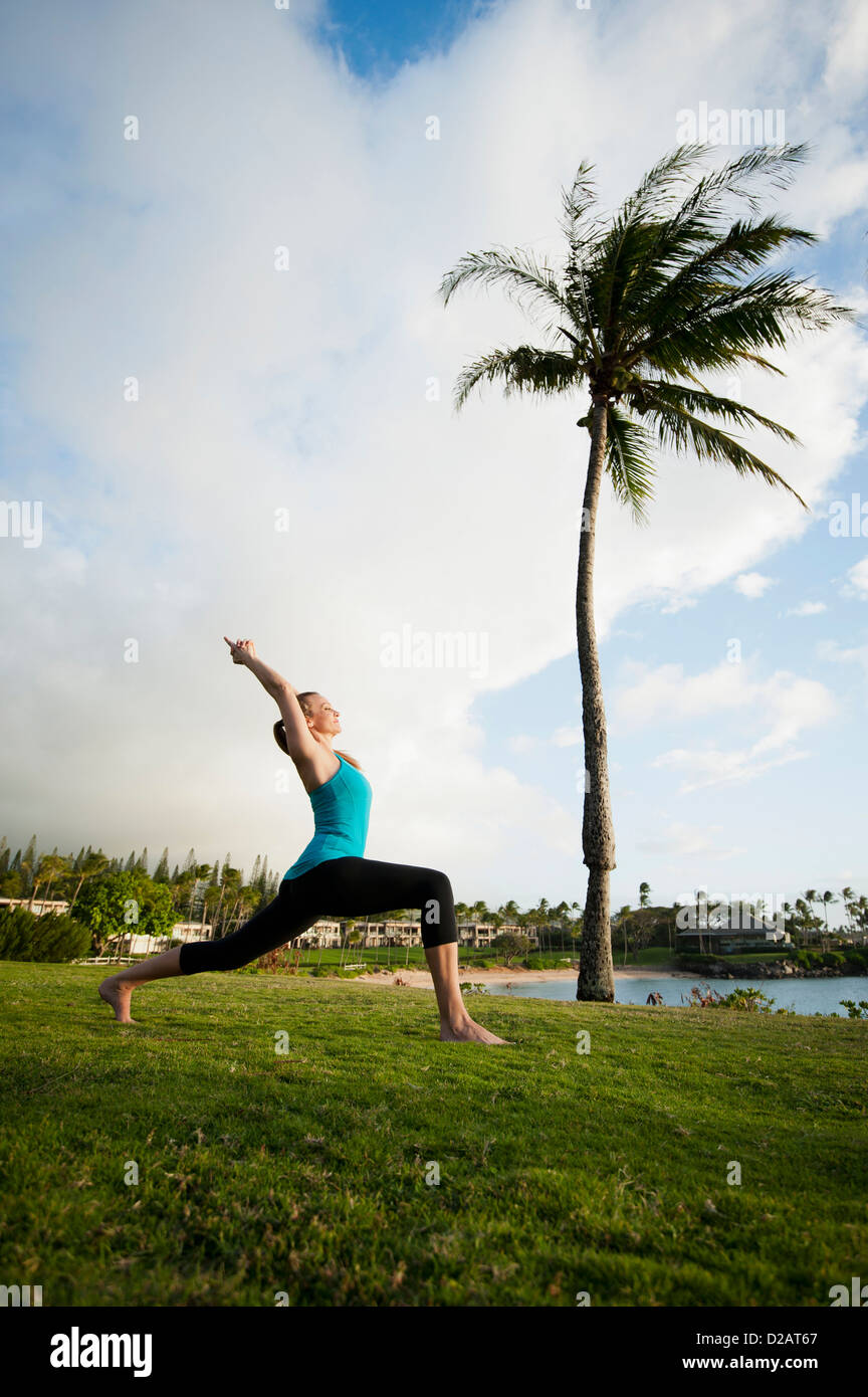 Woman practicing yoga in grassy field Stock Photo - Alamy