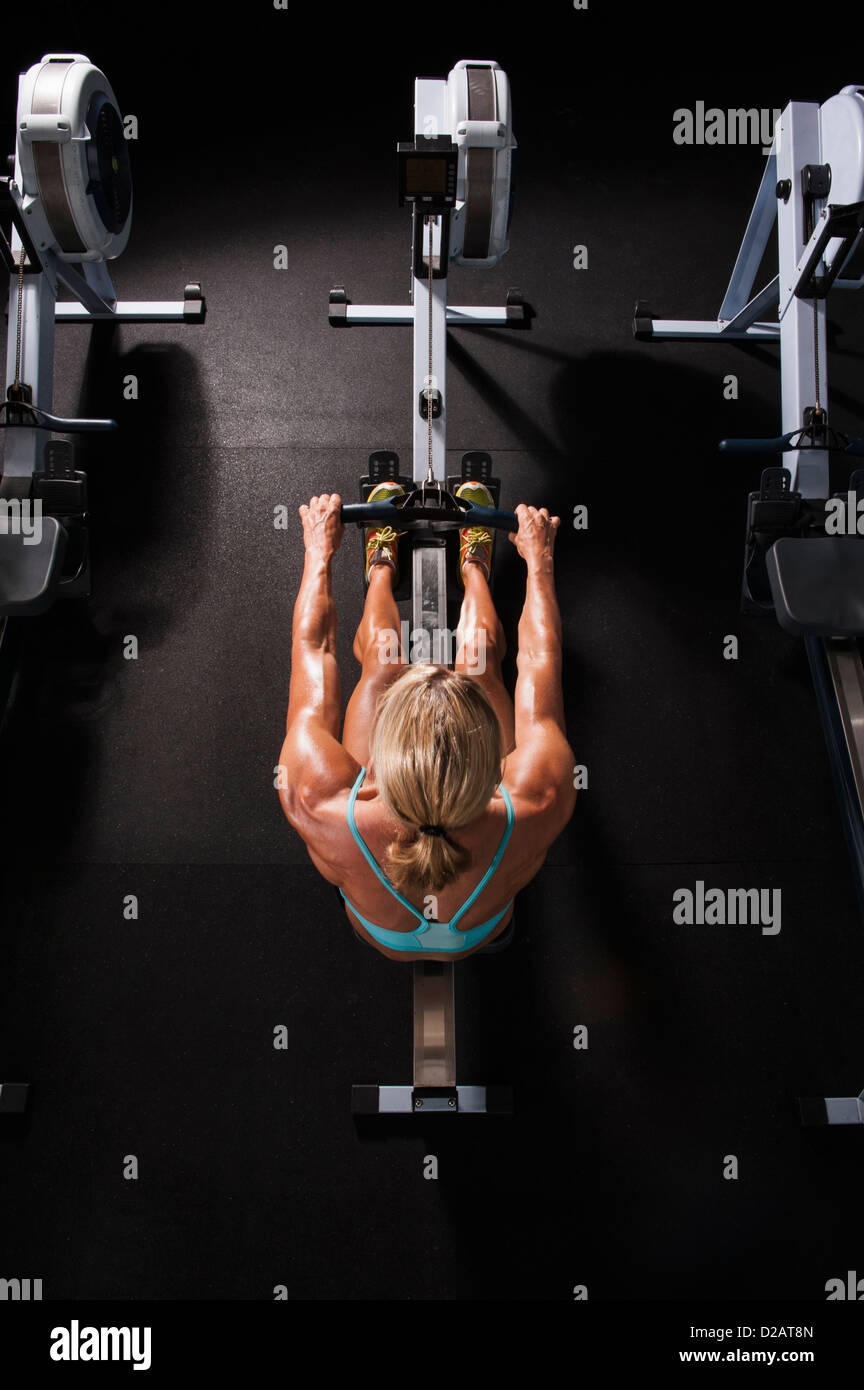Woman using exercise machine Stock Photo - Alamy