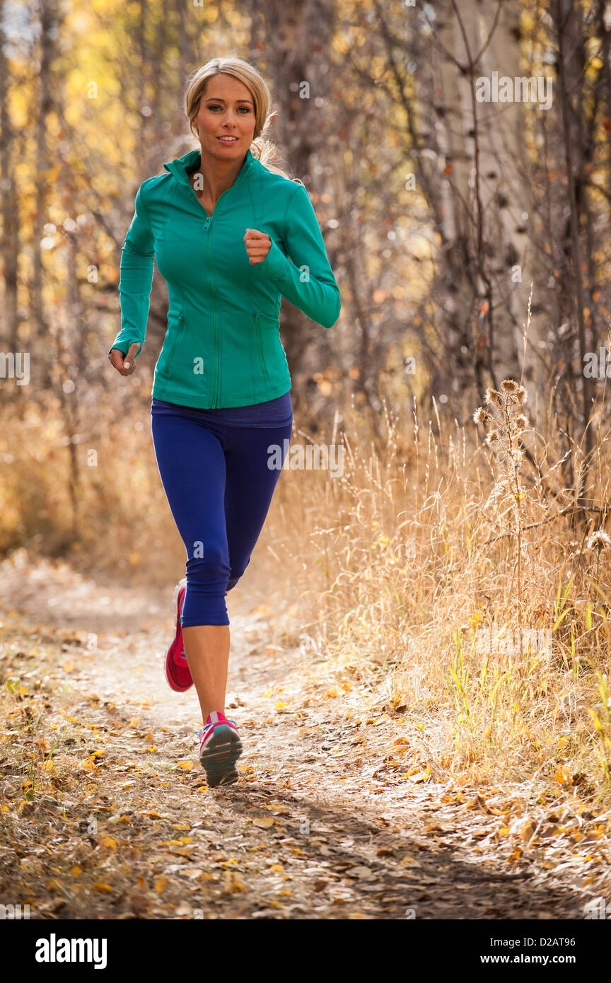 Woman jogging on dirt path Stock Photo - Alamy
