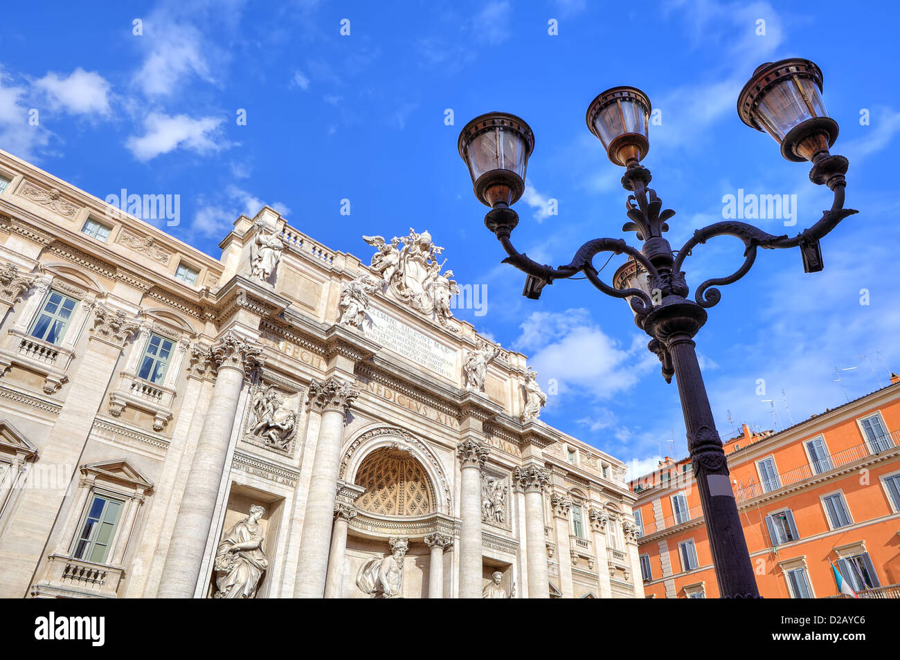 Traditional lamppost and fragment of famous Trevi Fountain under blue ...