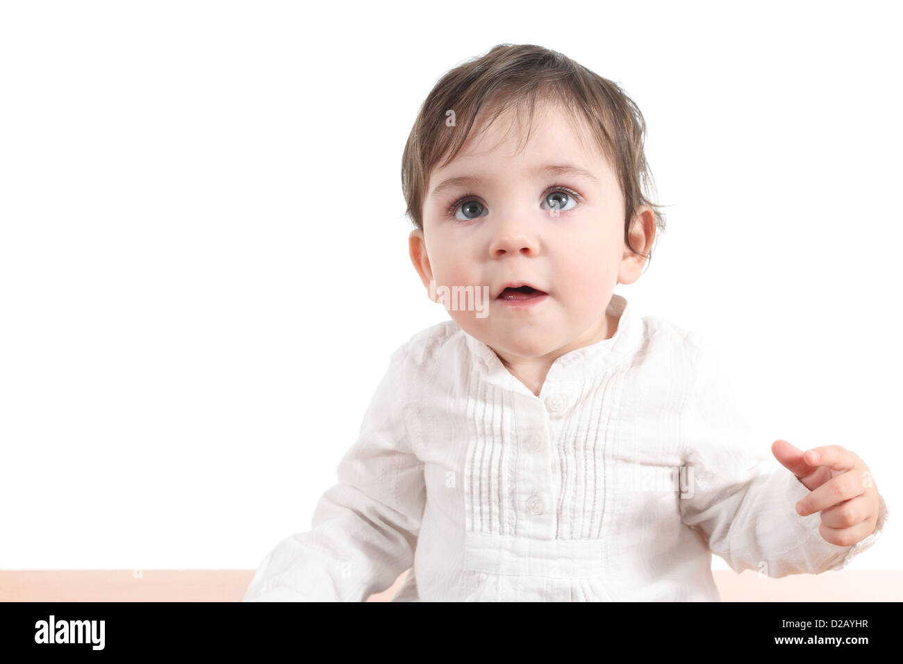 Baby puzzled watching up with a big blue eyes on a white isolated ...