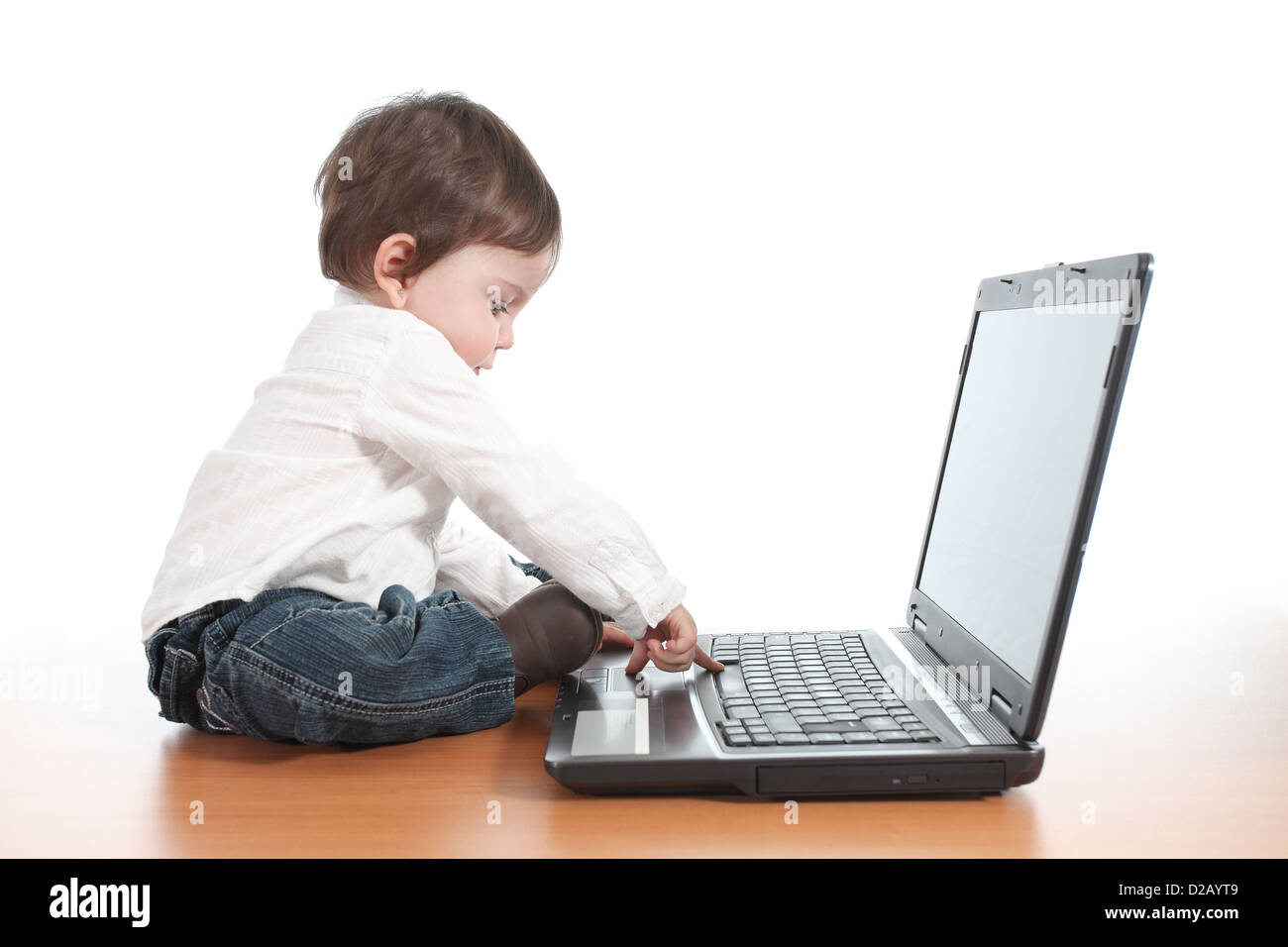 Casual baby typing on a laptop computer keyboard with a white isolated ...