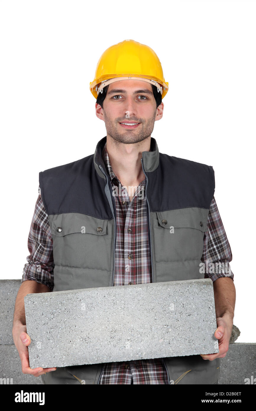 Young mason carrying a cinderblock Stock Photo - Alamy