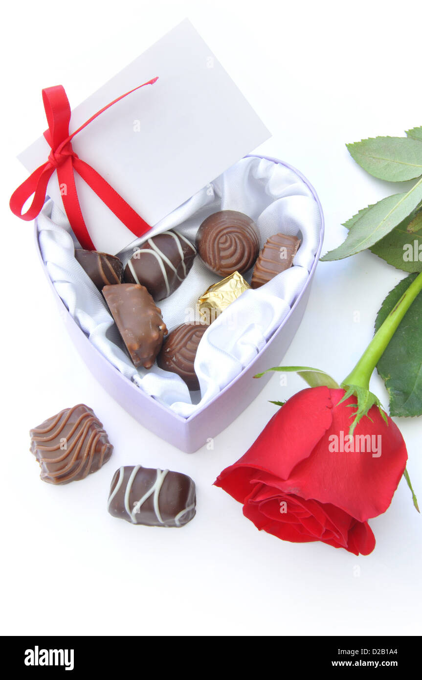 Red rose with heart shaped box of chocolates Stock Photo - Alamy