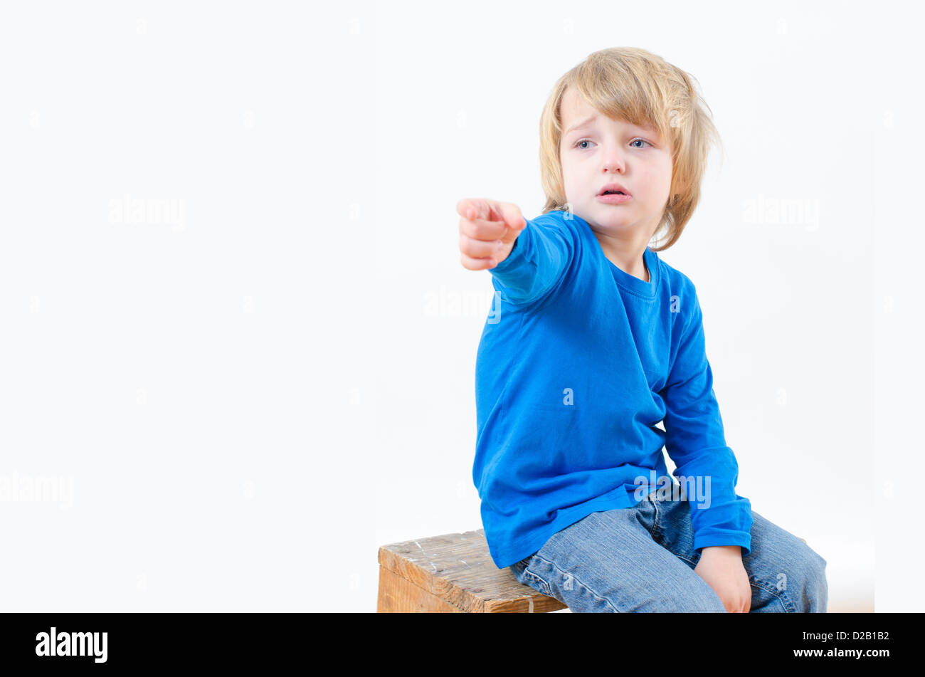 A cute sad boy pointing his finger to something imaginary Stock Photo ...