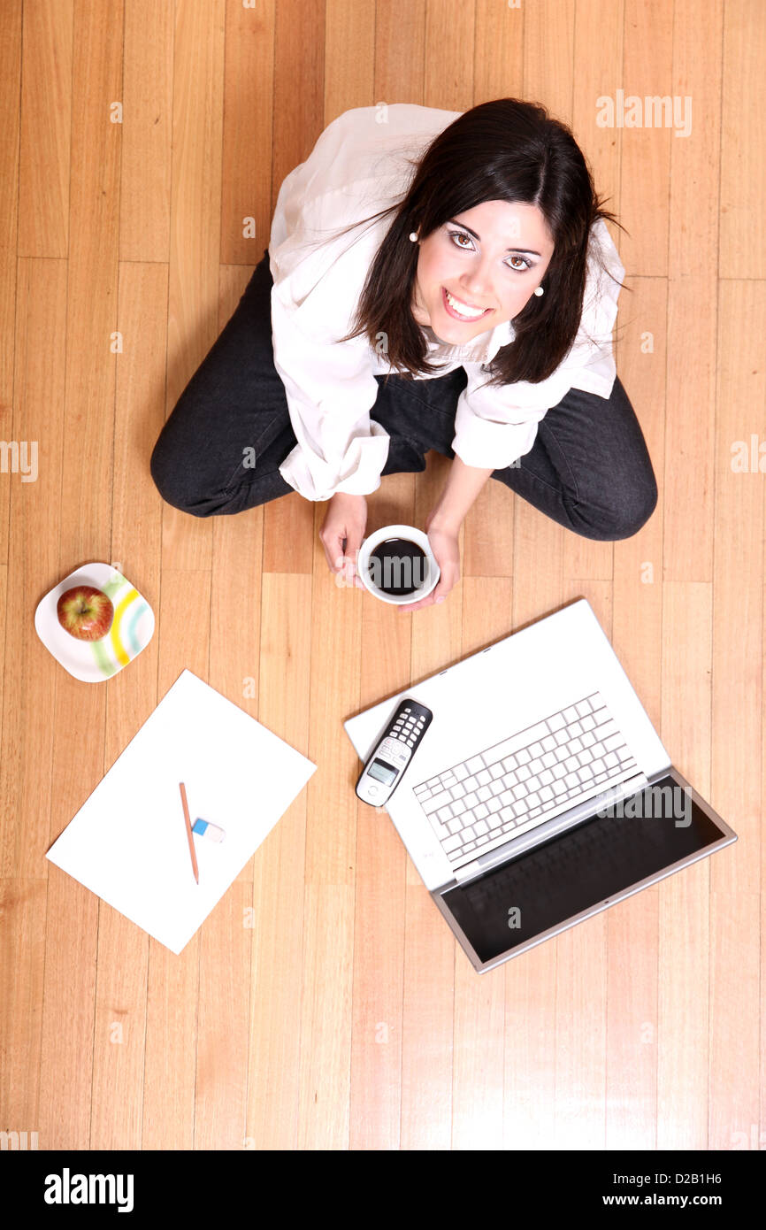 A young adult woman studying on the floor Stock Photo - Alamy