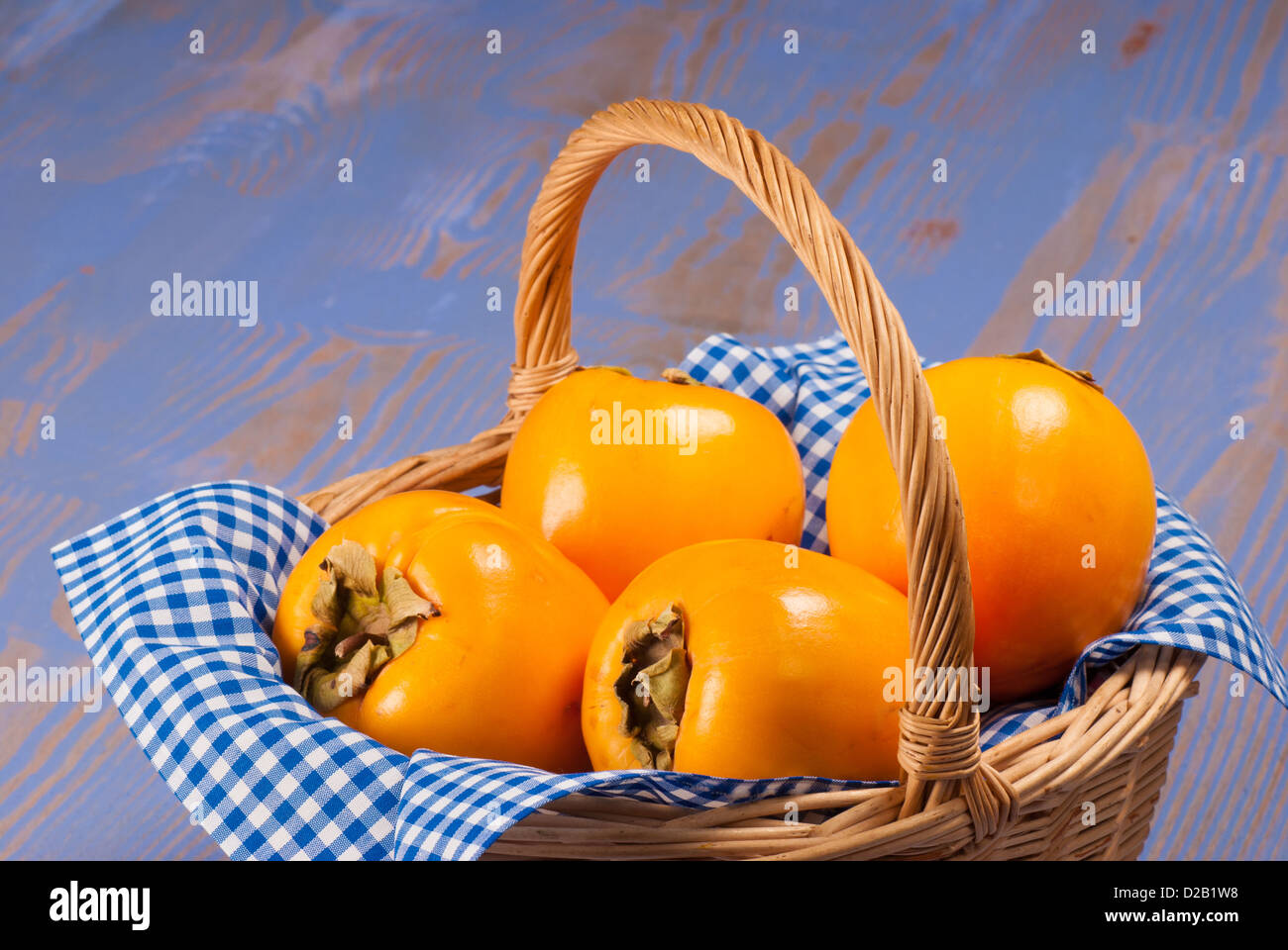 Delicious ripe persimmon inside a traditioal basket Stock Photo - Alamy