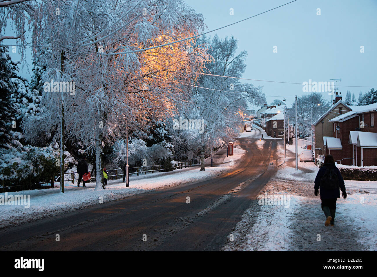 People walking in snowy conditions at dusk in town of Abergavenny ...