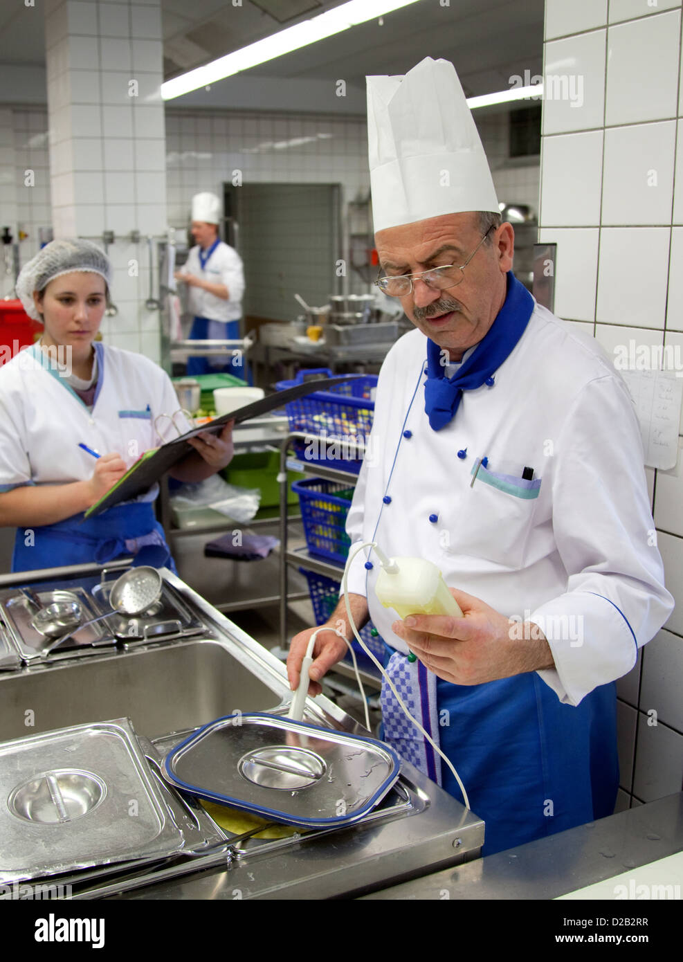 Essen, Germany, checks the food cooking in a Gastronormbehaelter Stock ...