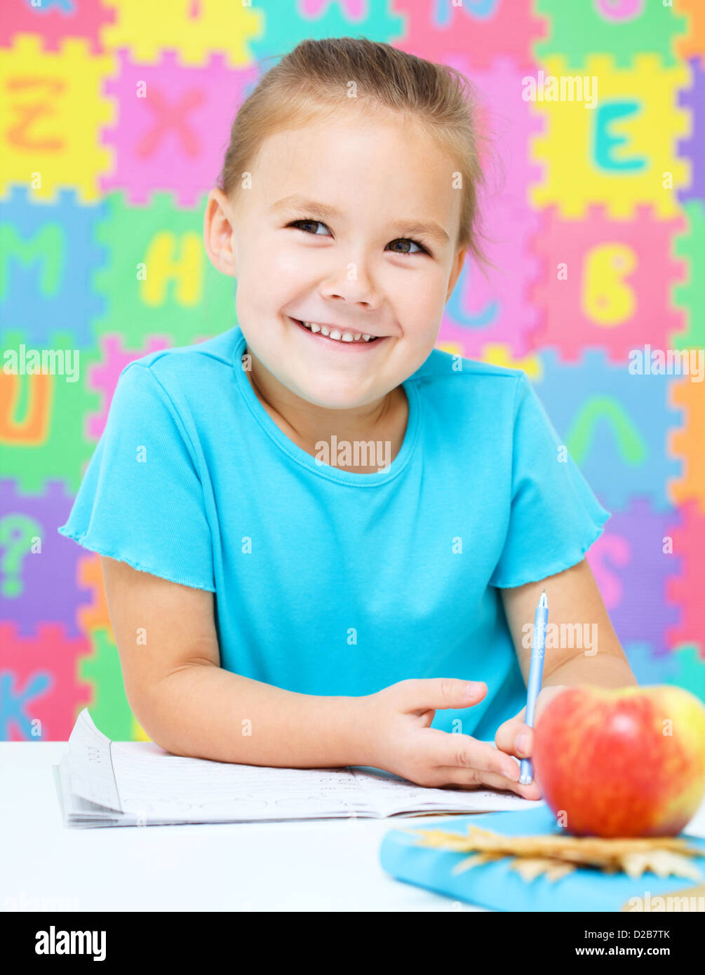 Cute little girl is writing using a pen in preschool Stock Photo - Alamy