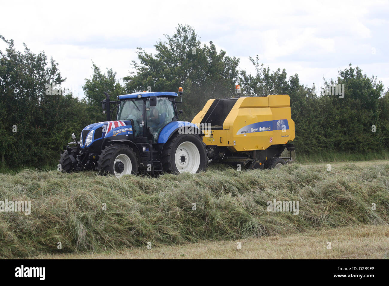 Tractor making bales of hay in a field in Essex Stock Photo - Alamy