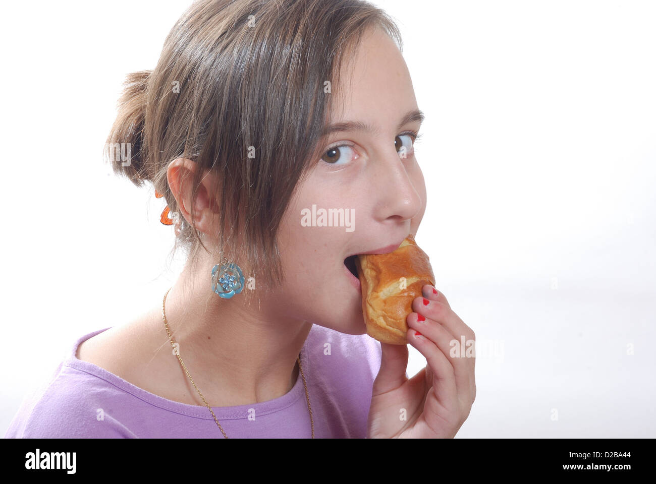 A young girl eating a bun Stock Photo - Alamy