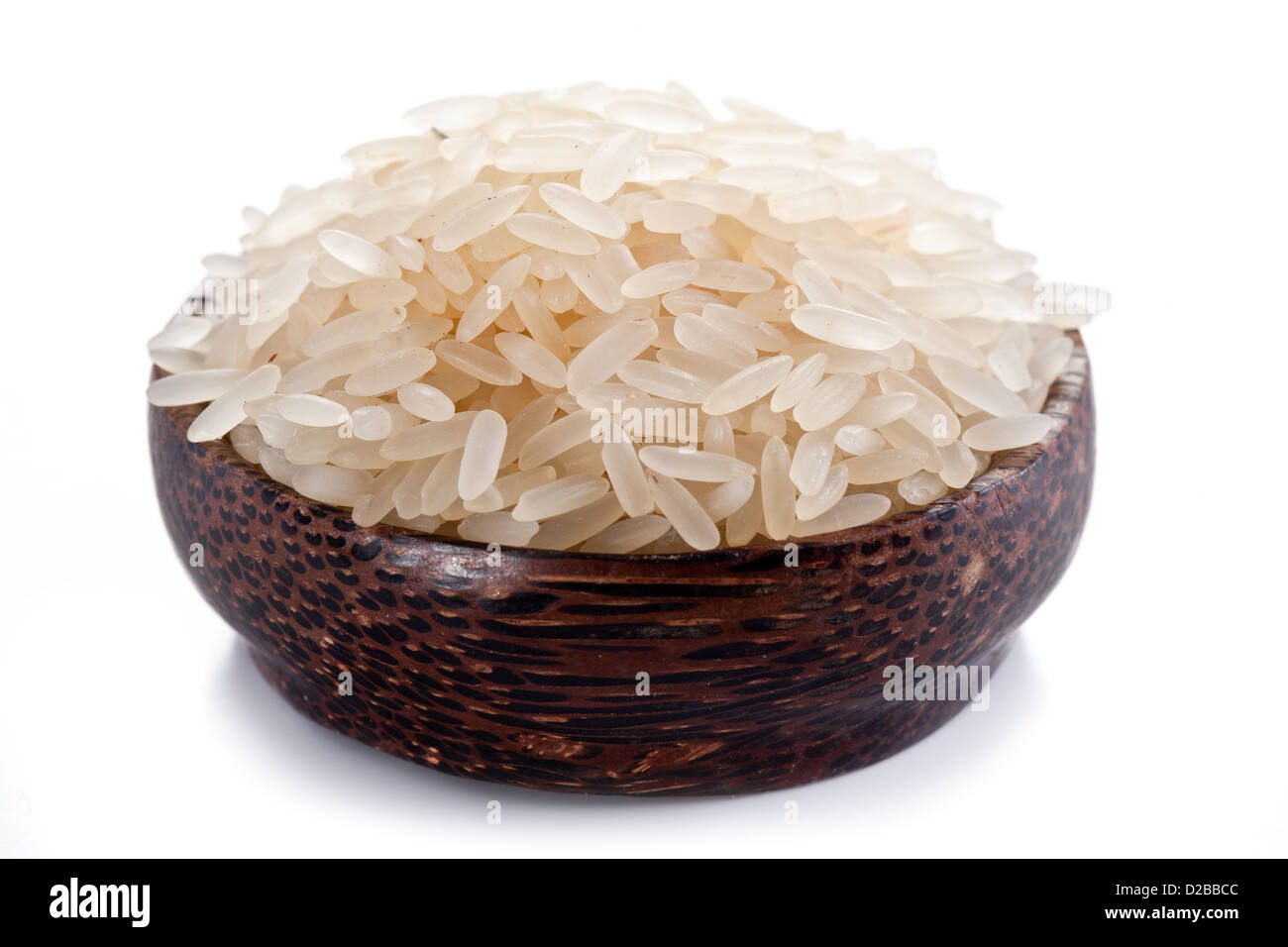 Uncooked rice in a wooden bowl on a white background Stock Photo - Alamy