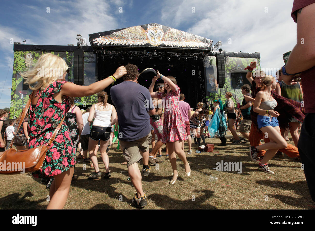 men and women dance in front of the main stage at BESTIVAL FESTIVAL ...