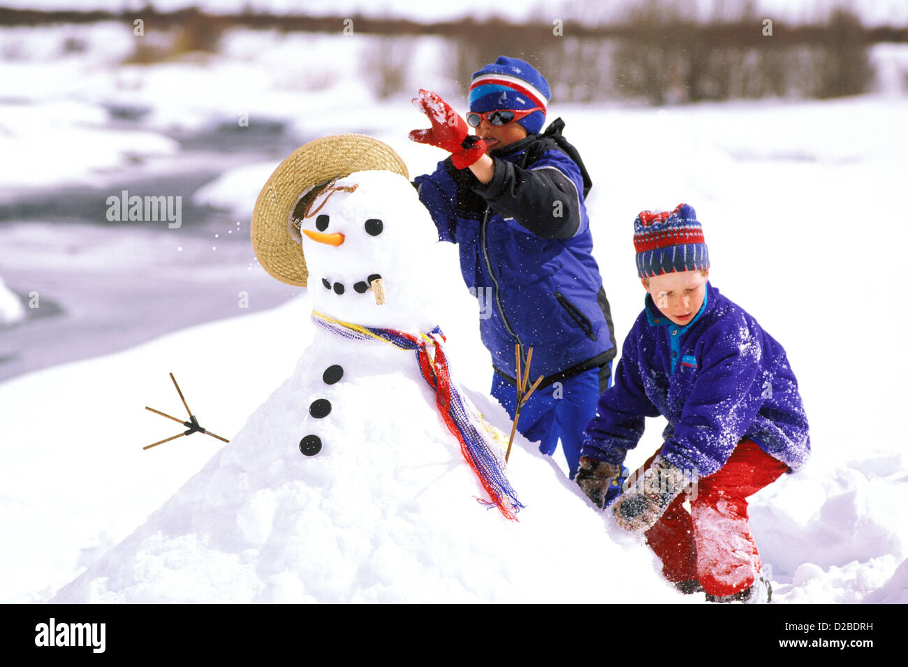 Children building a snowman hi-res stock photography and images - Alamy