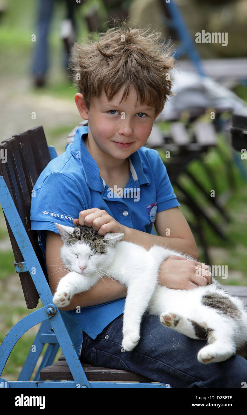 Resplendent village, Germany, boy petting a cat Stock Photo - Alamy