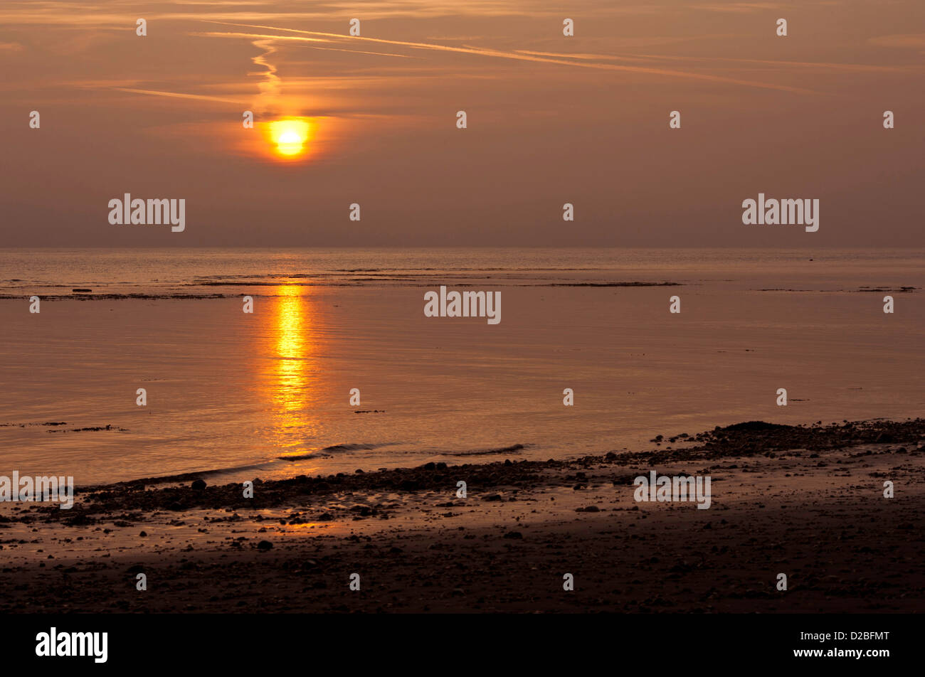 Sunrise over Bembridge beach on the Isle of Wight, sun reflected on the ...