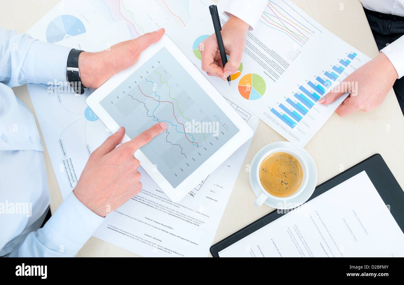 Business team analyzing income charts and graphs with modern digital ...