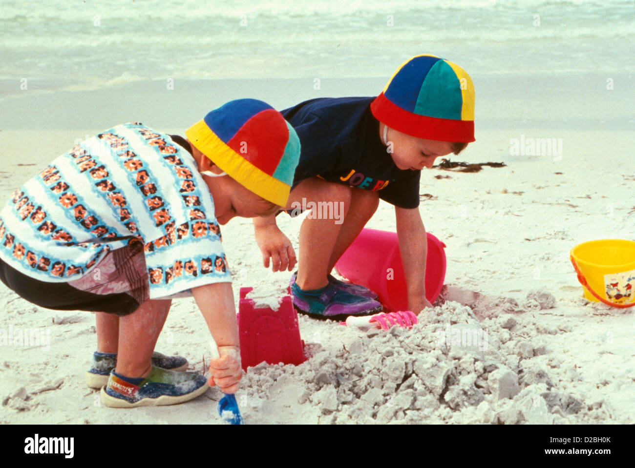 Two Brothers At The Beach Digging In The Sand, With Shovels And Pails ...