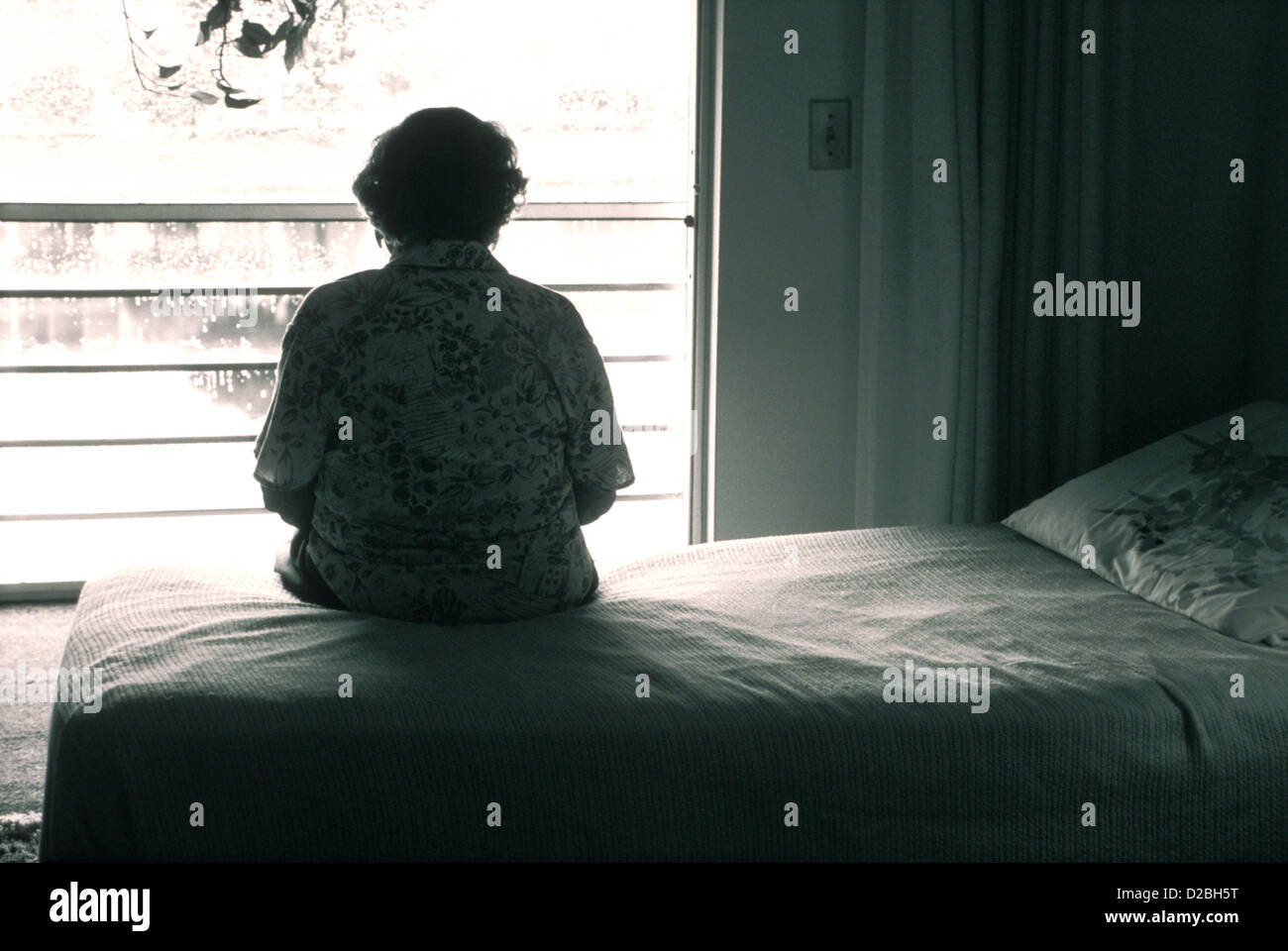 Elderly Female Silhouette, Sitting On Her Bed Looking Out Window Stock ...