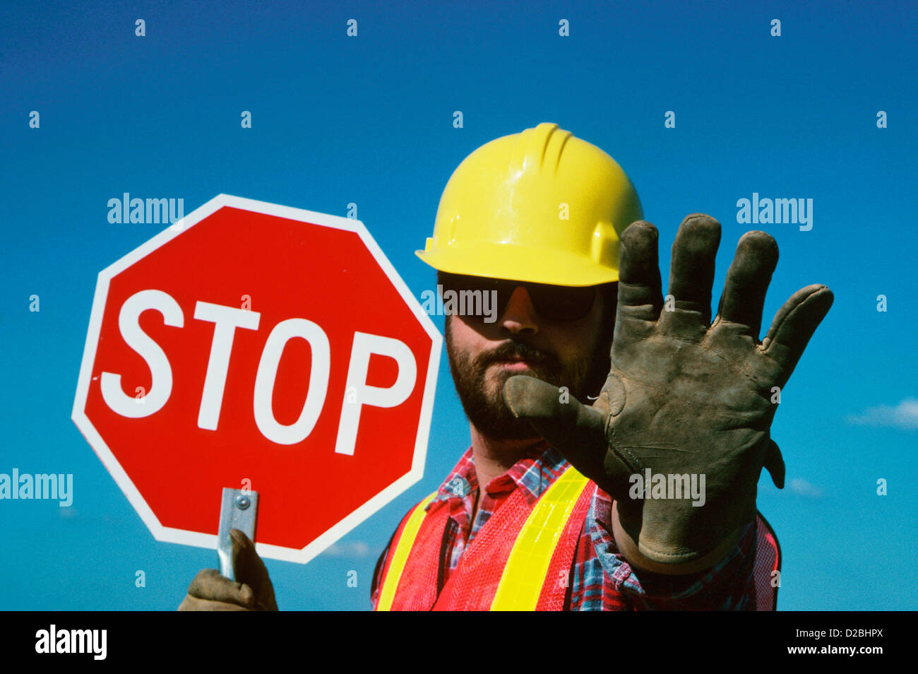 Workman with hardhat holding up stop sign hi-res stock photography and ...
