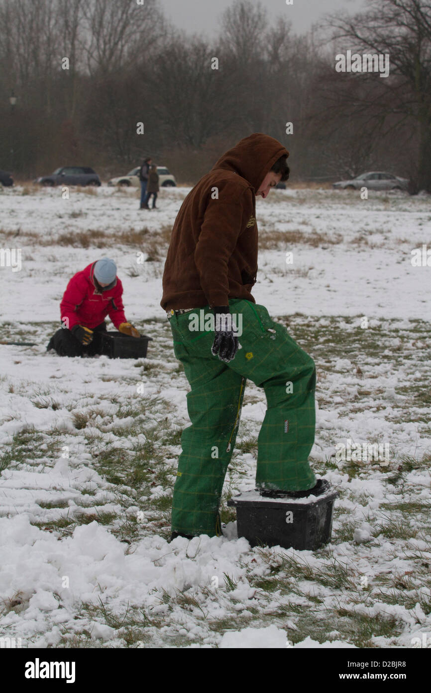19th January 2013. A man scoops snow on to a bucket on Wimbledon common ...
