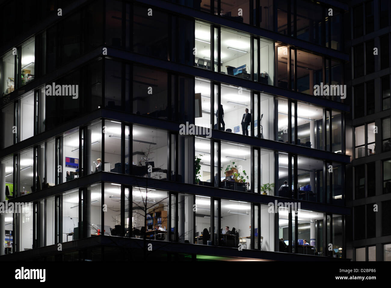 Berlin, Germany, a man standing at the window of his illuminated ...