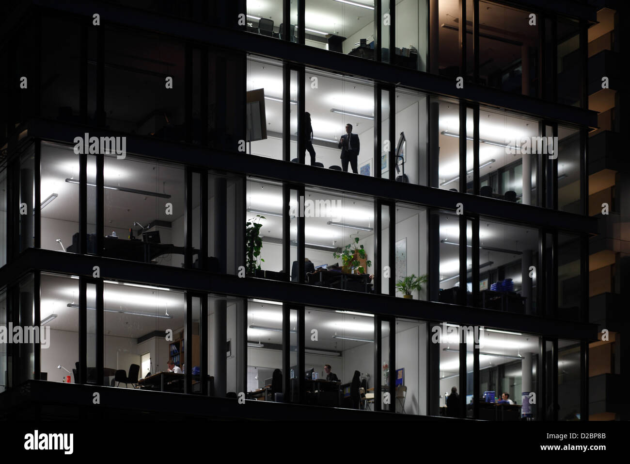 Berlin, Germany, a man standing at the window of his illuminated ...