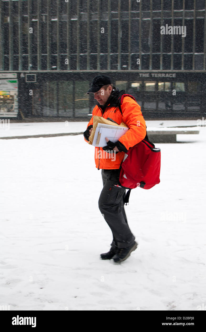 Postman in snowy weather, Coventry city centre, UK Stock Photo - Alamy