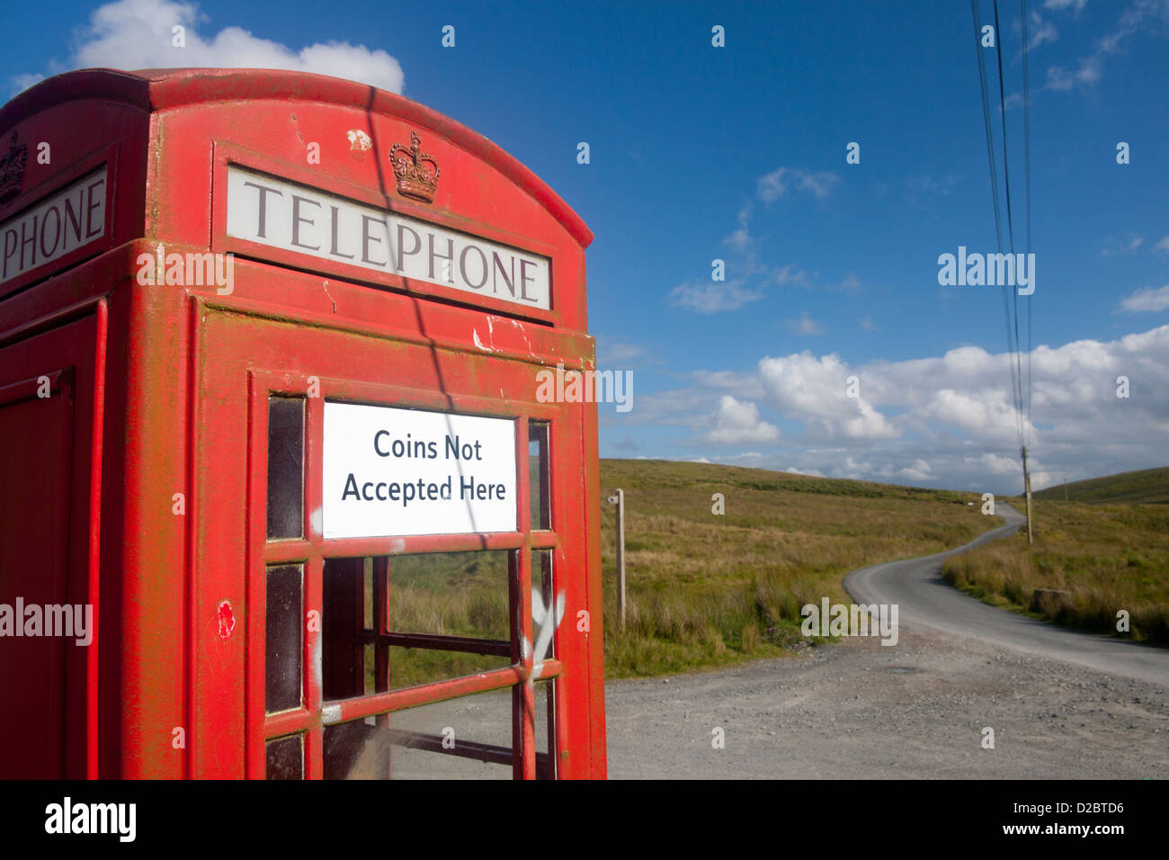 Traditional red telephone box on remote moorland / mountain road ...