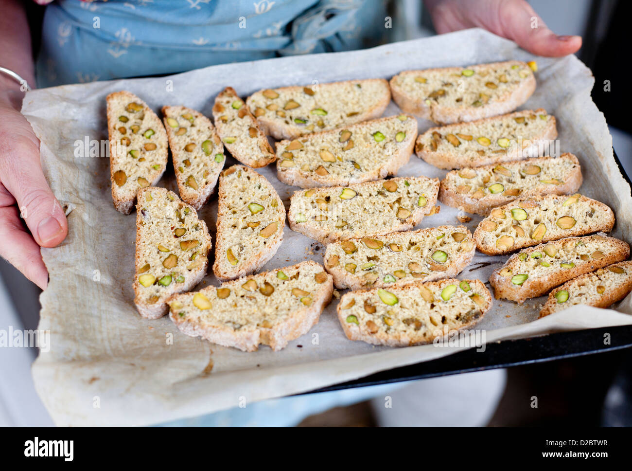 Biscotti. Pistachio flavoured home baked biscuits on a hand held baking ...