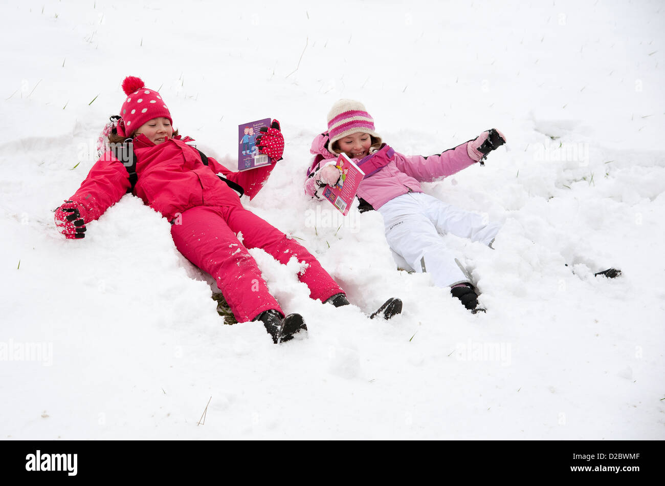 Winter snow scene with children playing 'Snow Angels' on the roadside ...