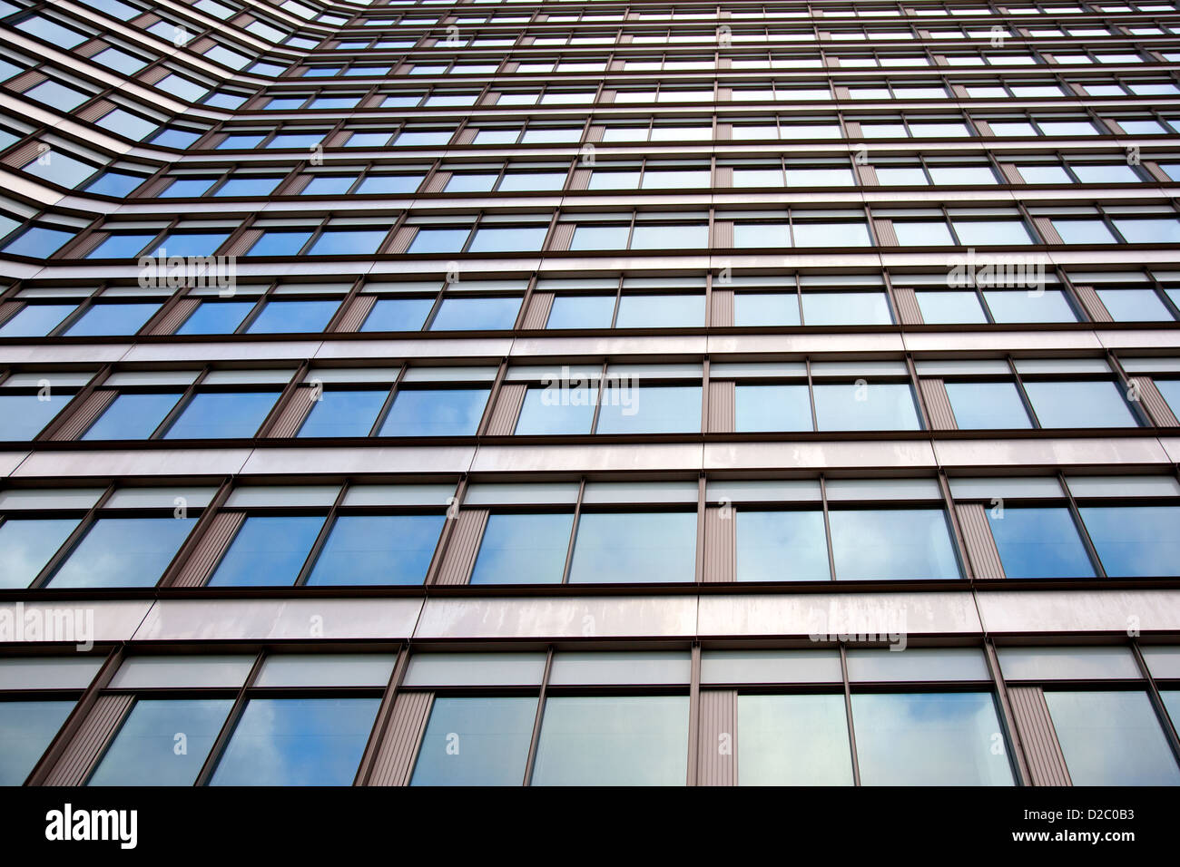 facade of office building with regular pattern windows reflecting white ...