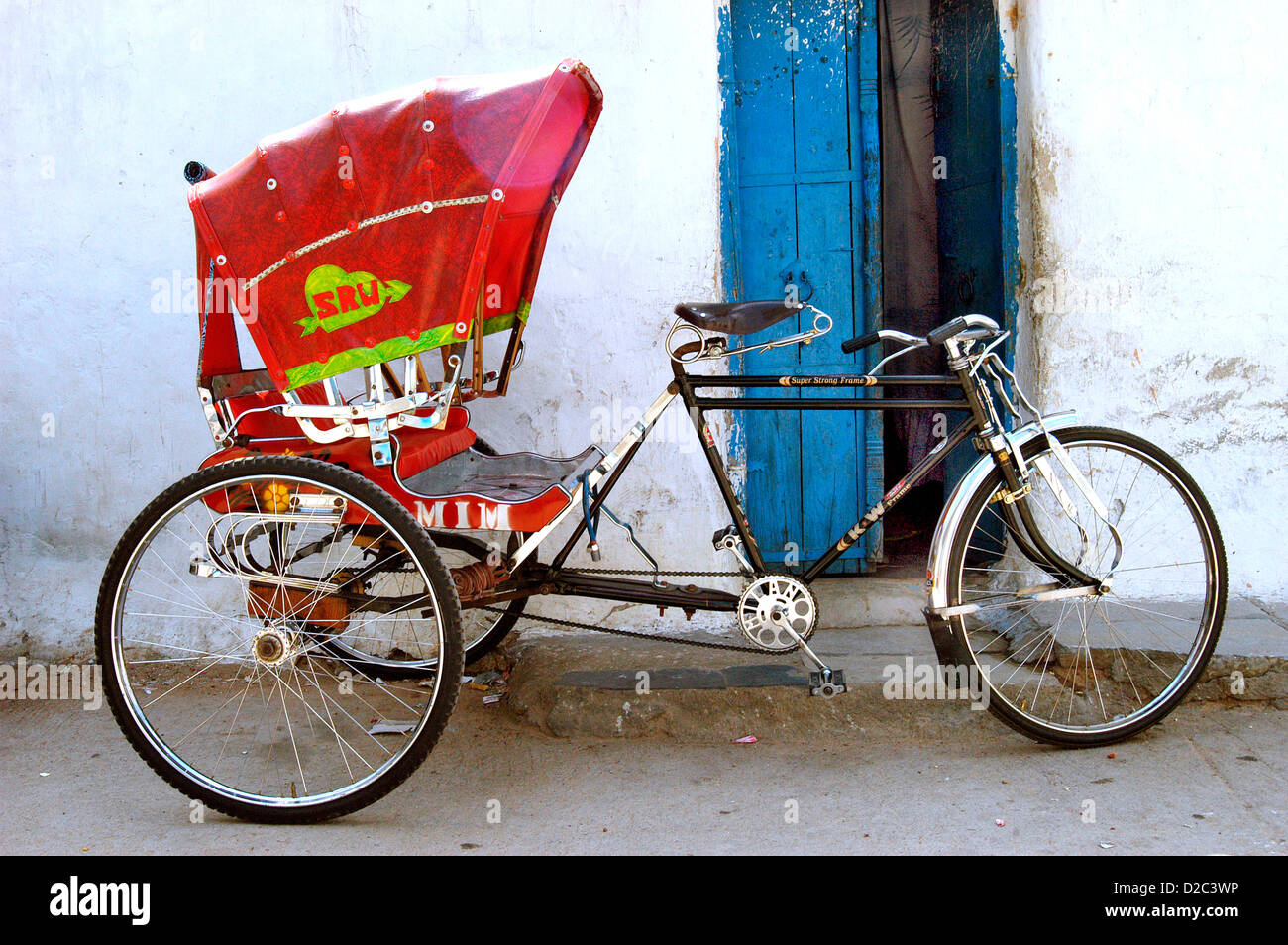 Colorful Red Cycle Rickshaw Standing In Front Of Blue Door In Old City ...