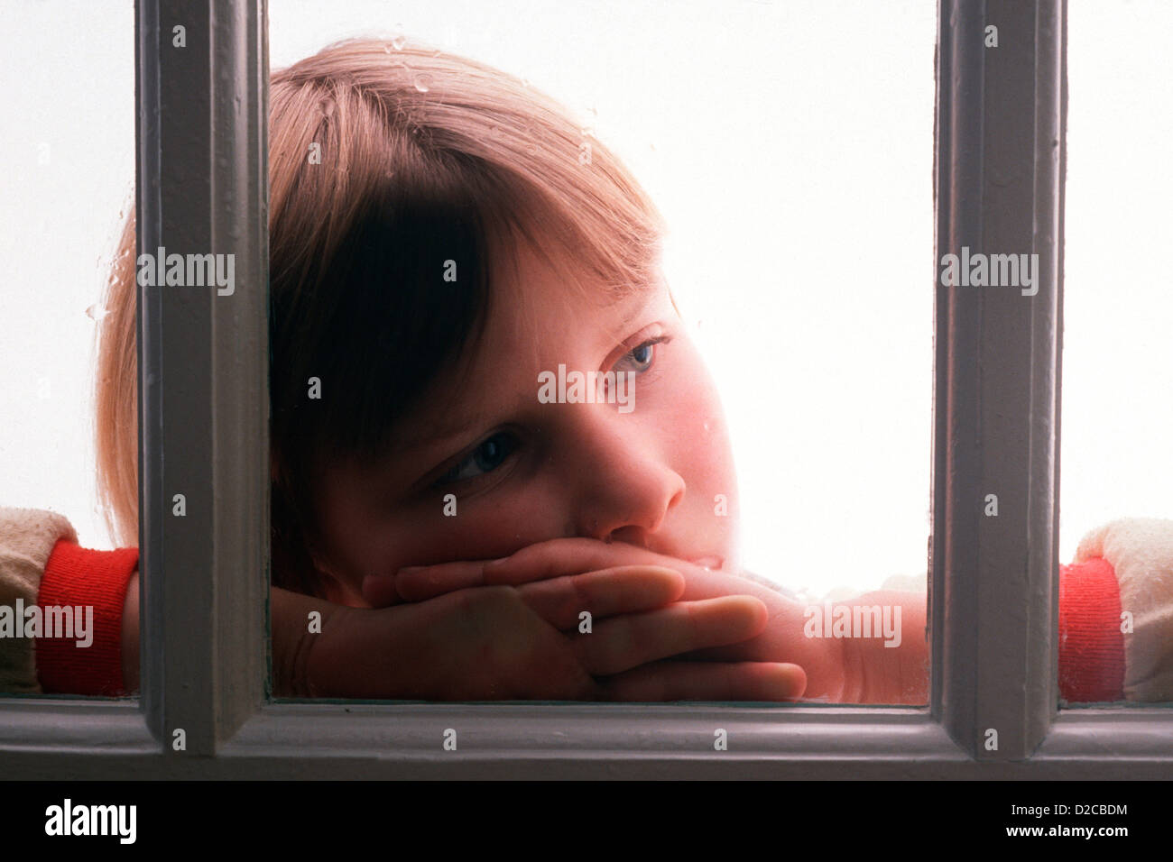 Lonely Child Standing At Her Window Looking Outdoors Stock Photo - Alamy