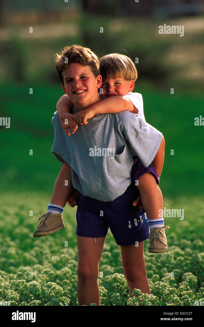 Boy giving piggyback ride his brother brothers hi-res stock photography ...