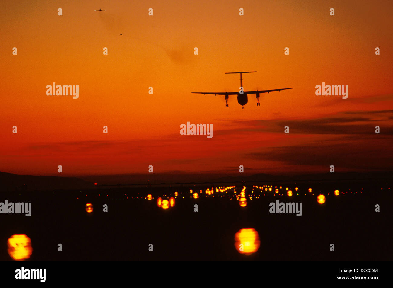 Silhouetted Jet Landing, Orange Sky Stock Photo - Alamy