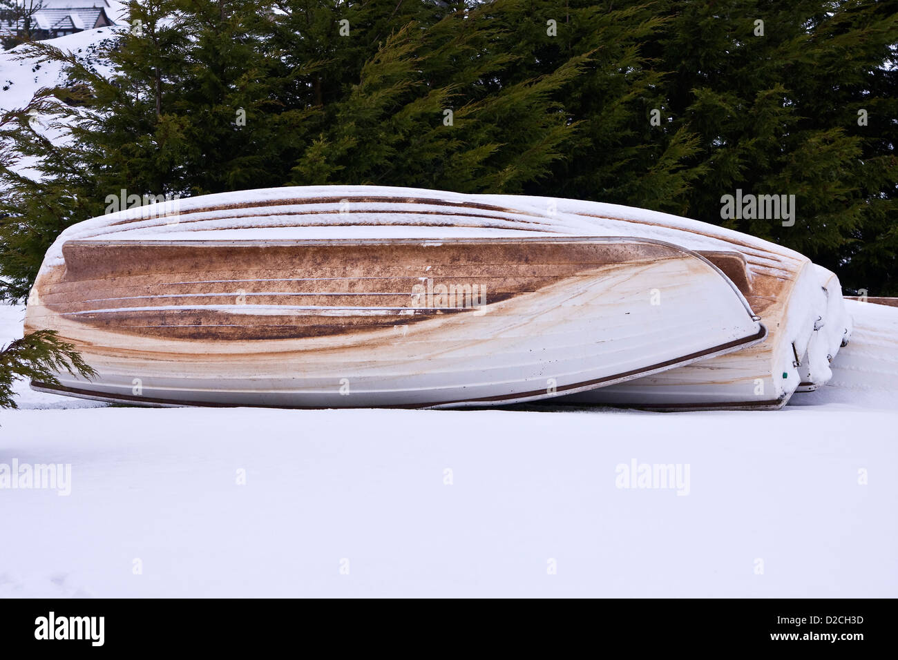 Rowing boats laying upside down in the fresh snowfall close to the ...